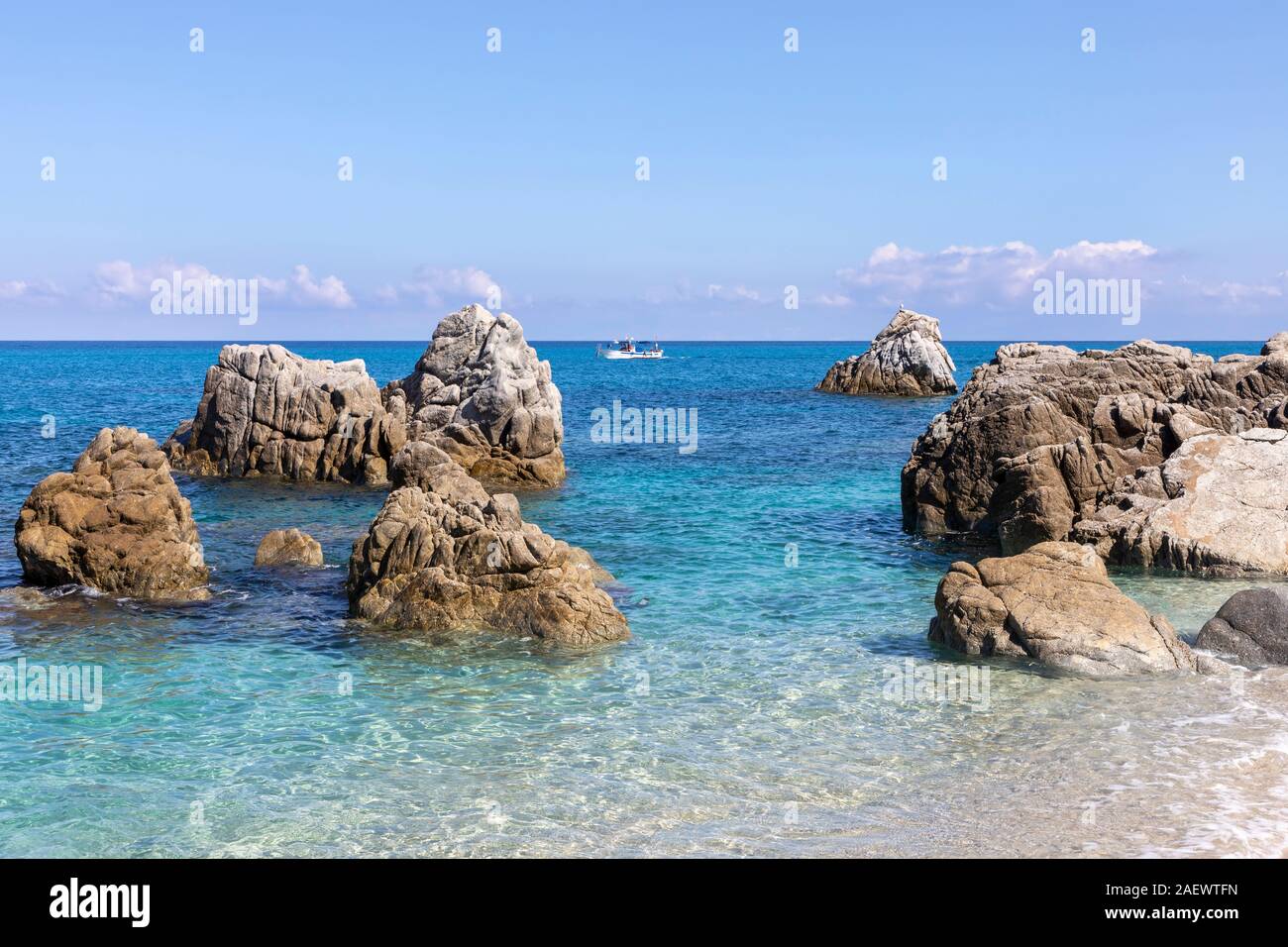 fishing boat sailing past rocky outcrops on beach at tropea italy Stock ...