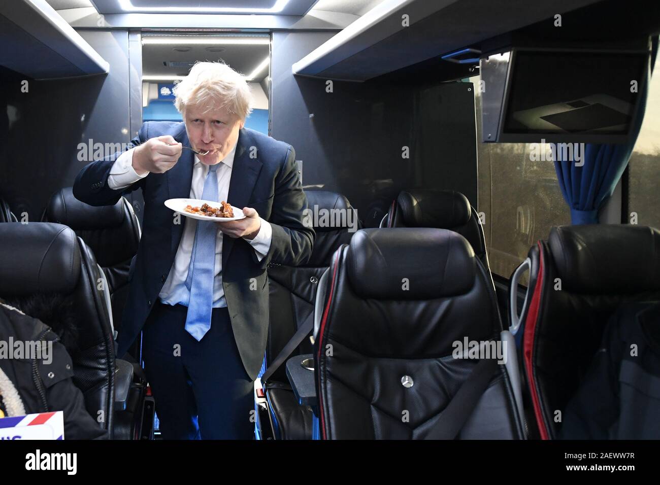 Prime Minister Boris Johnson eats a pie on his campaign bus following a ...
