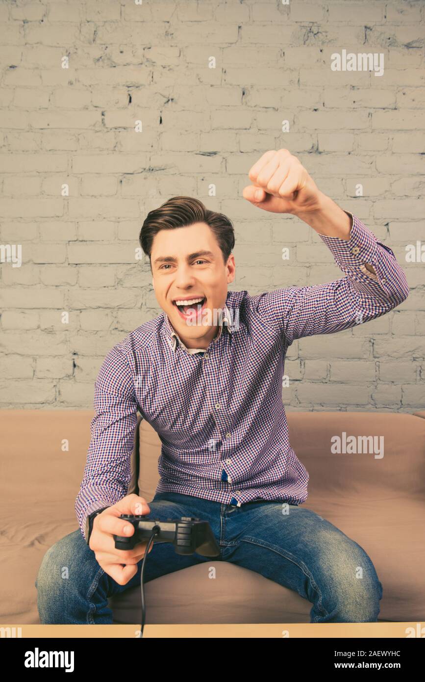 Portrait of happy man winning video game with raised fist Stock Photo ...