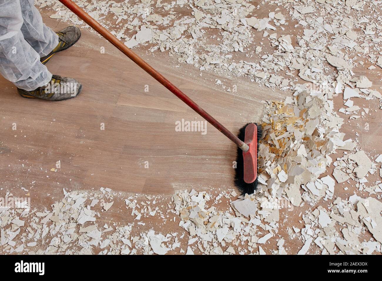 Builder sweeping the floor after renovation Stock Photo - Alamy