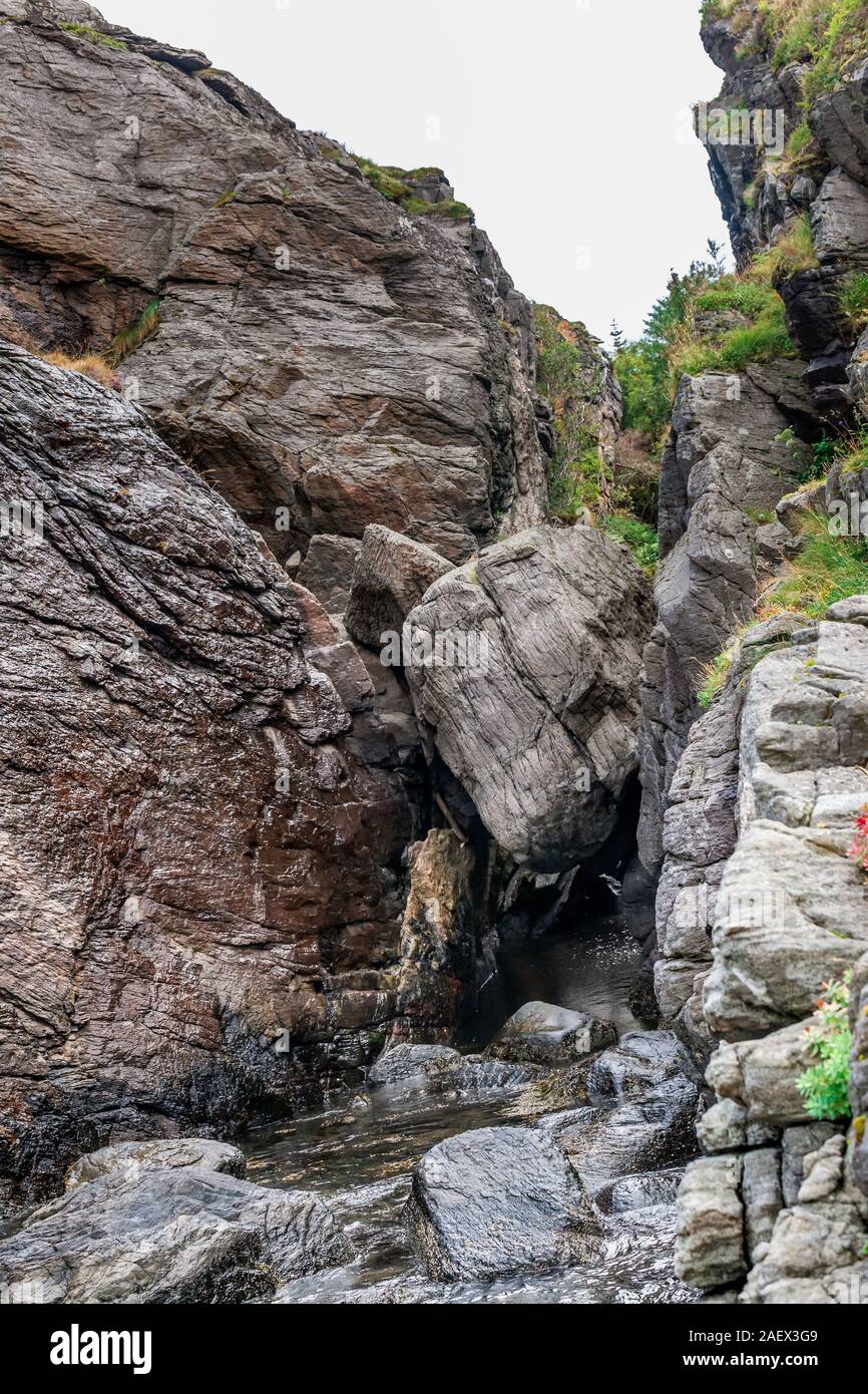 Boulder stuck between two granite cliffs at Lofoten islands, Norway ...