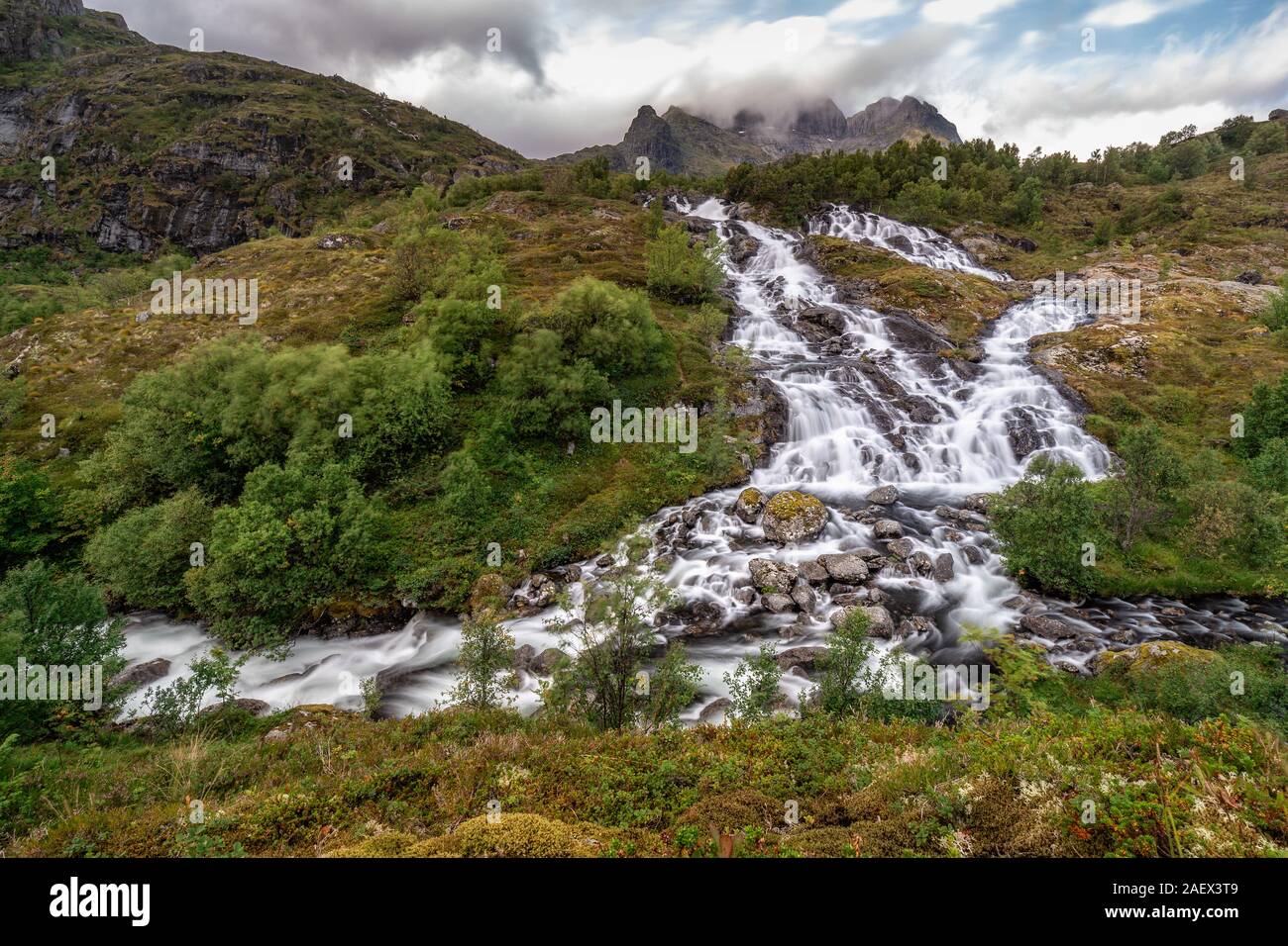 Beautiful waterfall among the autumn forest and mountains. on the road ...