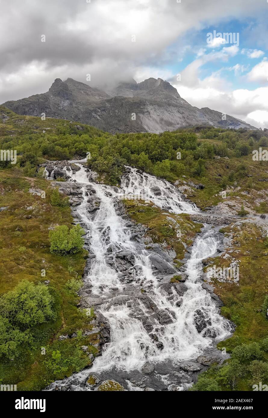 Beautiful waterfall among the autumn forest and mountains. on the road ...