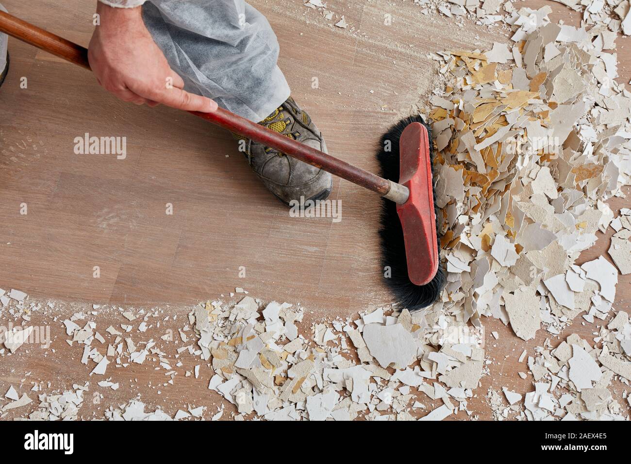 Builder sweeping the floor after renovation Stock Photo - Alamy