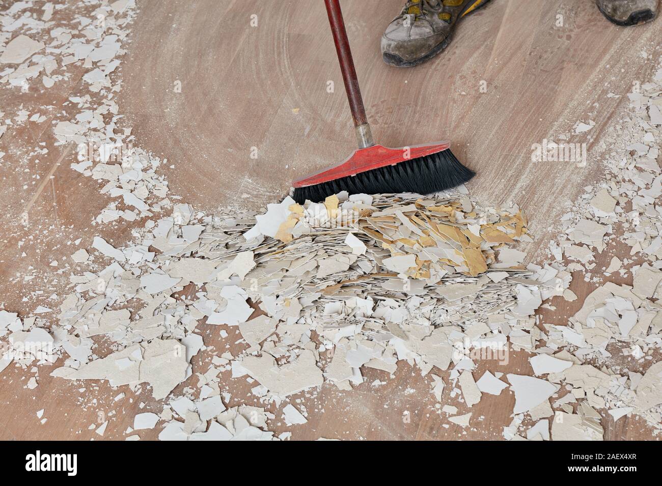 Builder sweeping the floor after renovation Stock Photo - Alamy