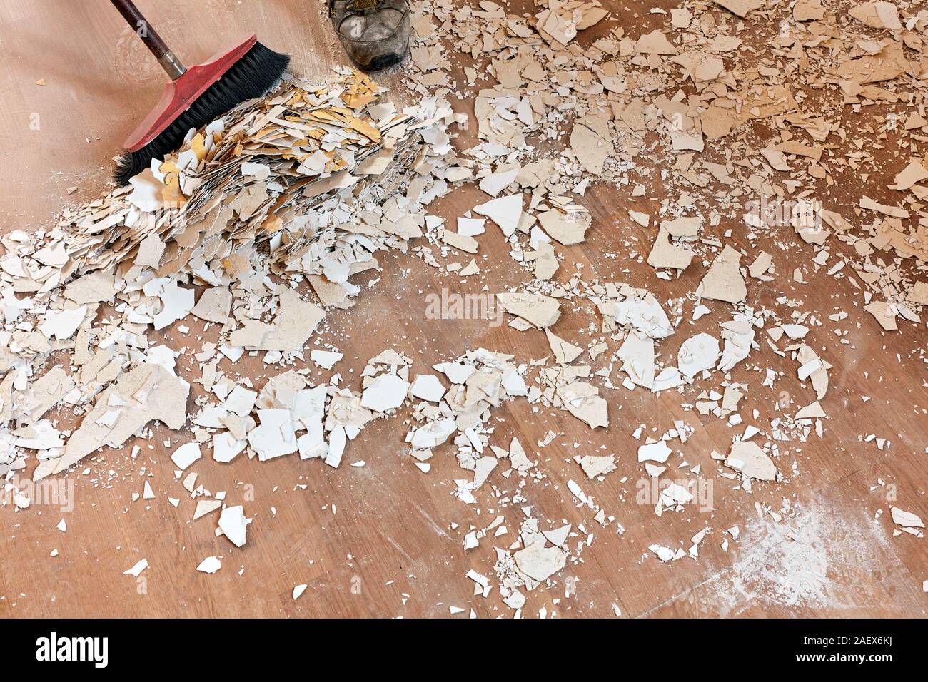 Builder sweeping the wooden floor after renovation Stock Photo - Alamy