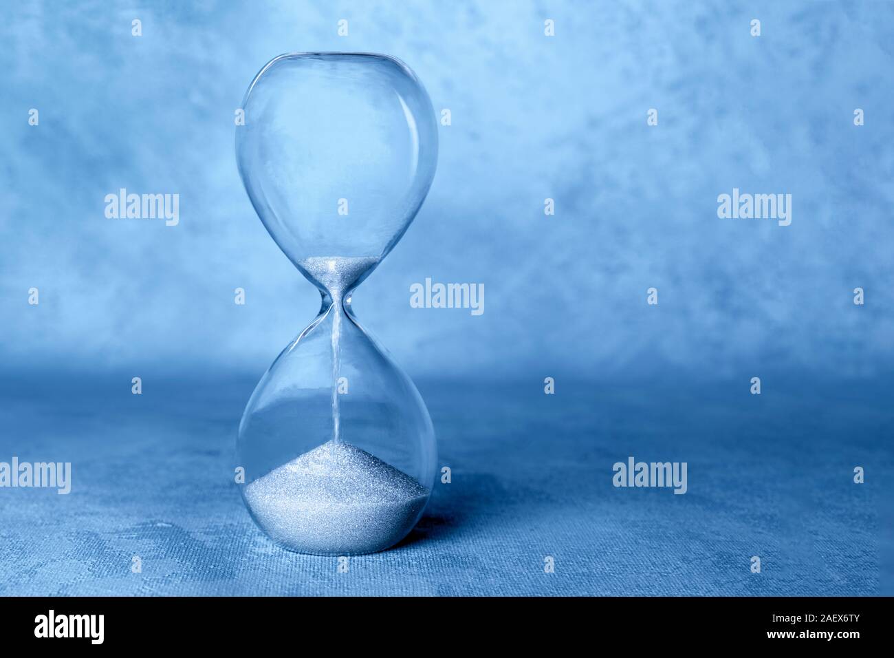 Time is running out concept. An hourglass with sand falling through ...