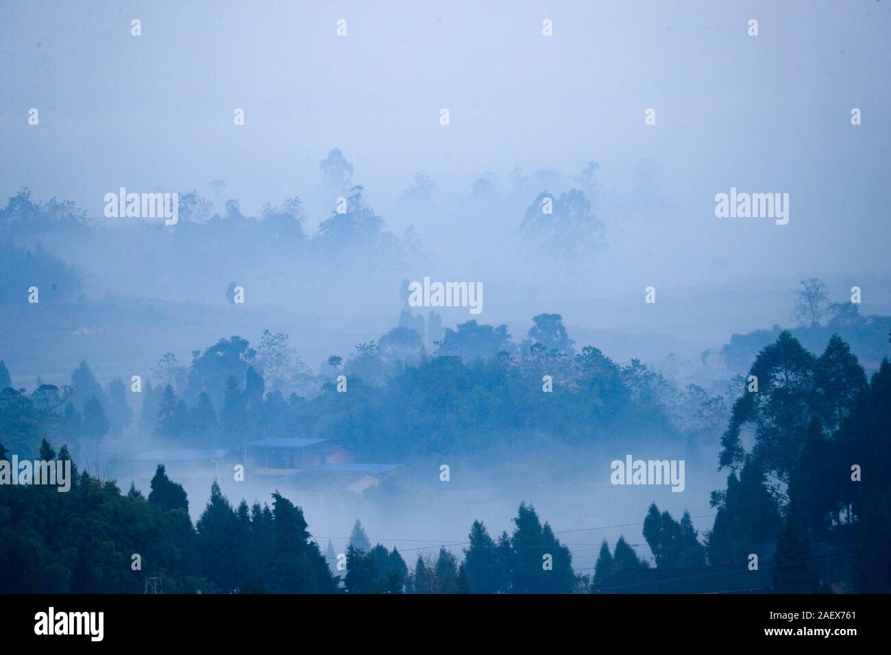 Landscape of mountains and villages shrouded by mist in the early ...