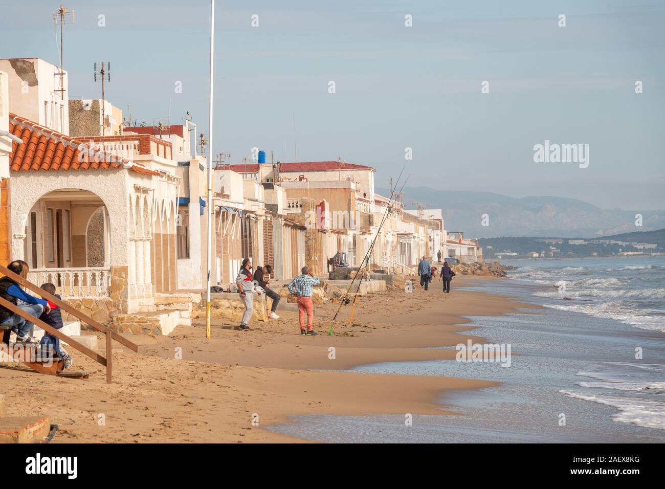 Beach front housing and people sea fishing at Playa De Pinet, La Marina ...