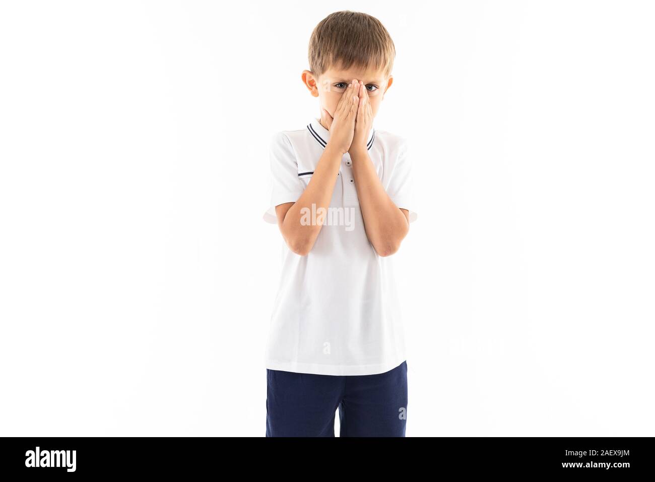 outgoing boy with bangs in a white t-shirt on a white background with ...
