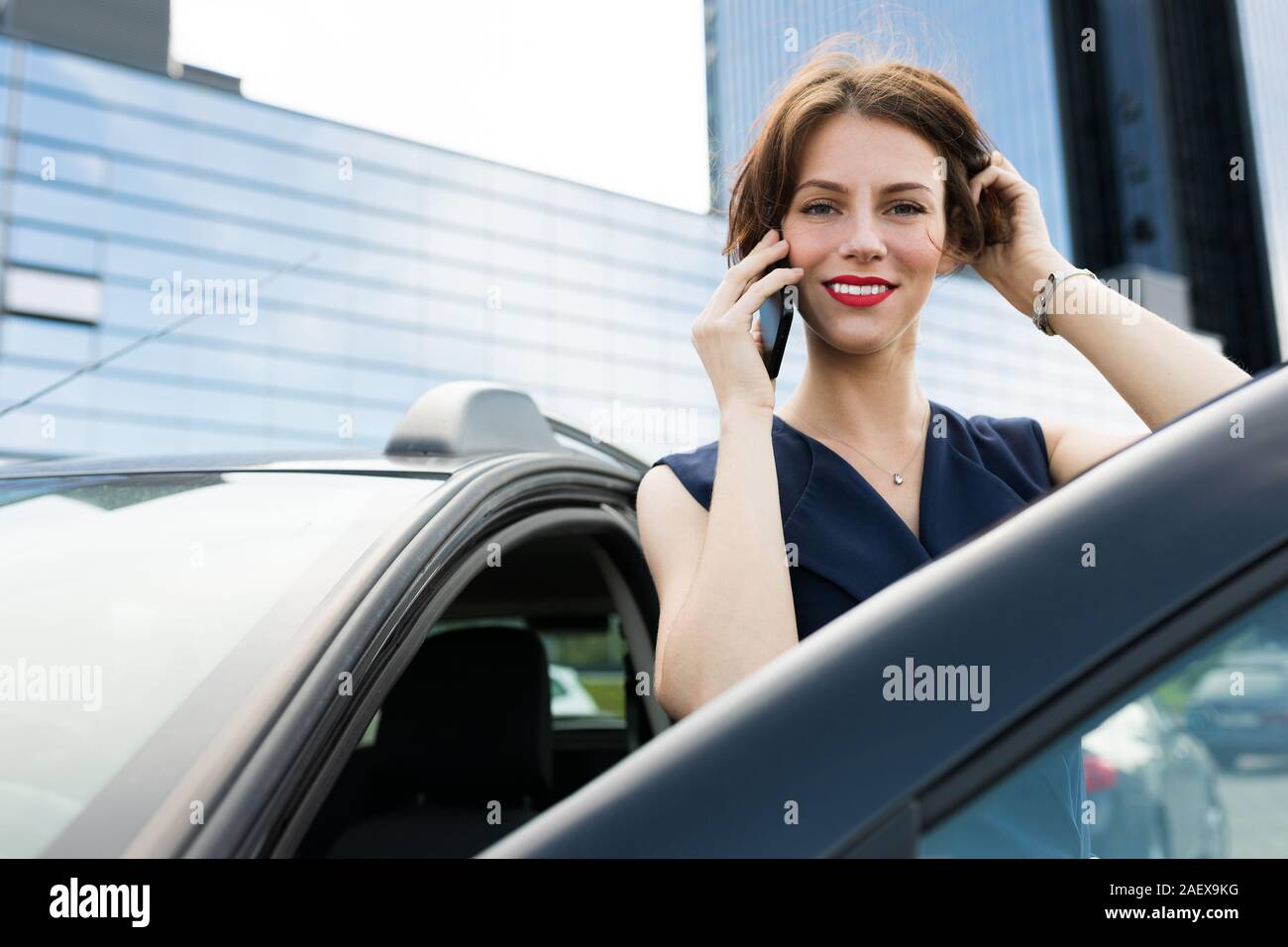 Beautiful girl in strict style of clothing gets out of the car for an ...