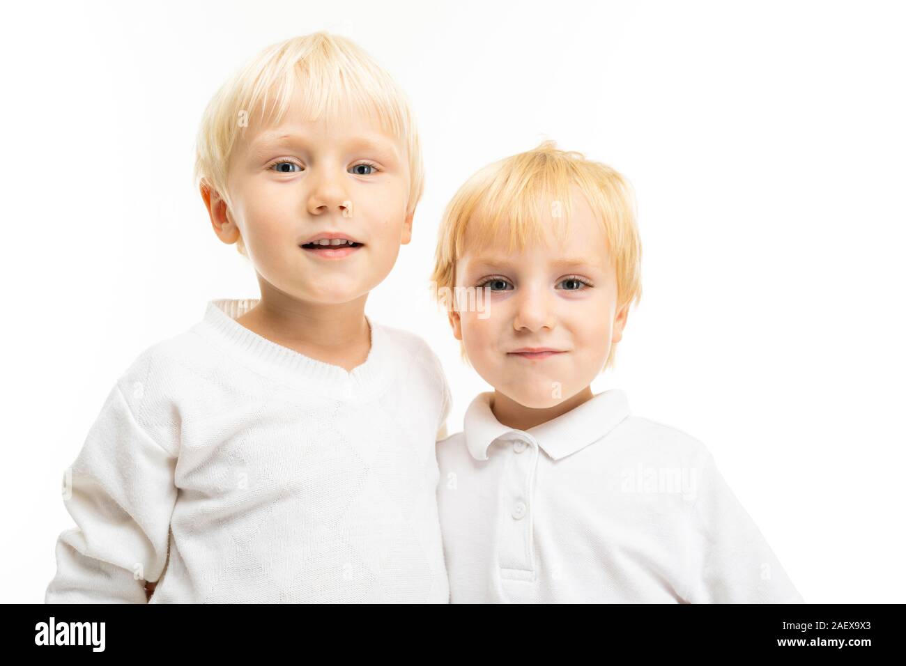 Two little caucasian brothers with blonde and fair red hair smiles ...
