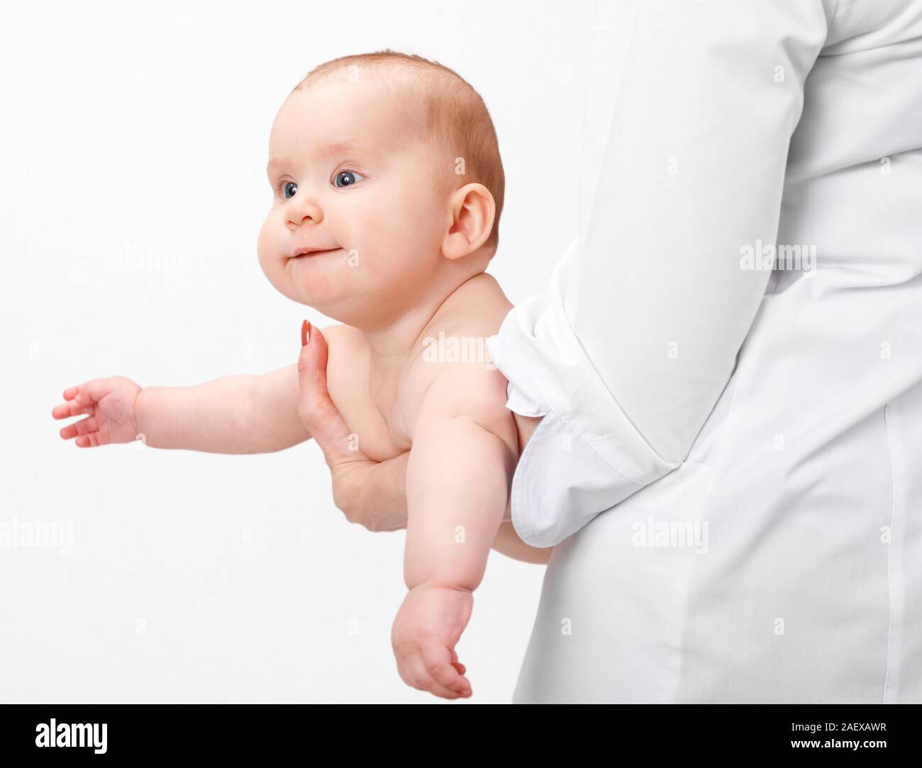 Doctor holding six month baby girl in pediatric clinic ready to perform ...