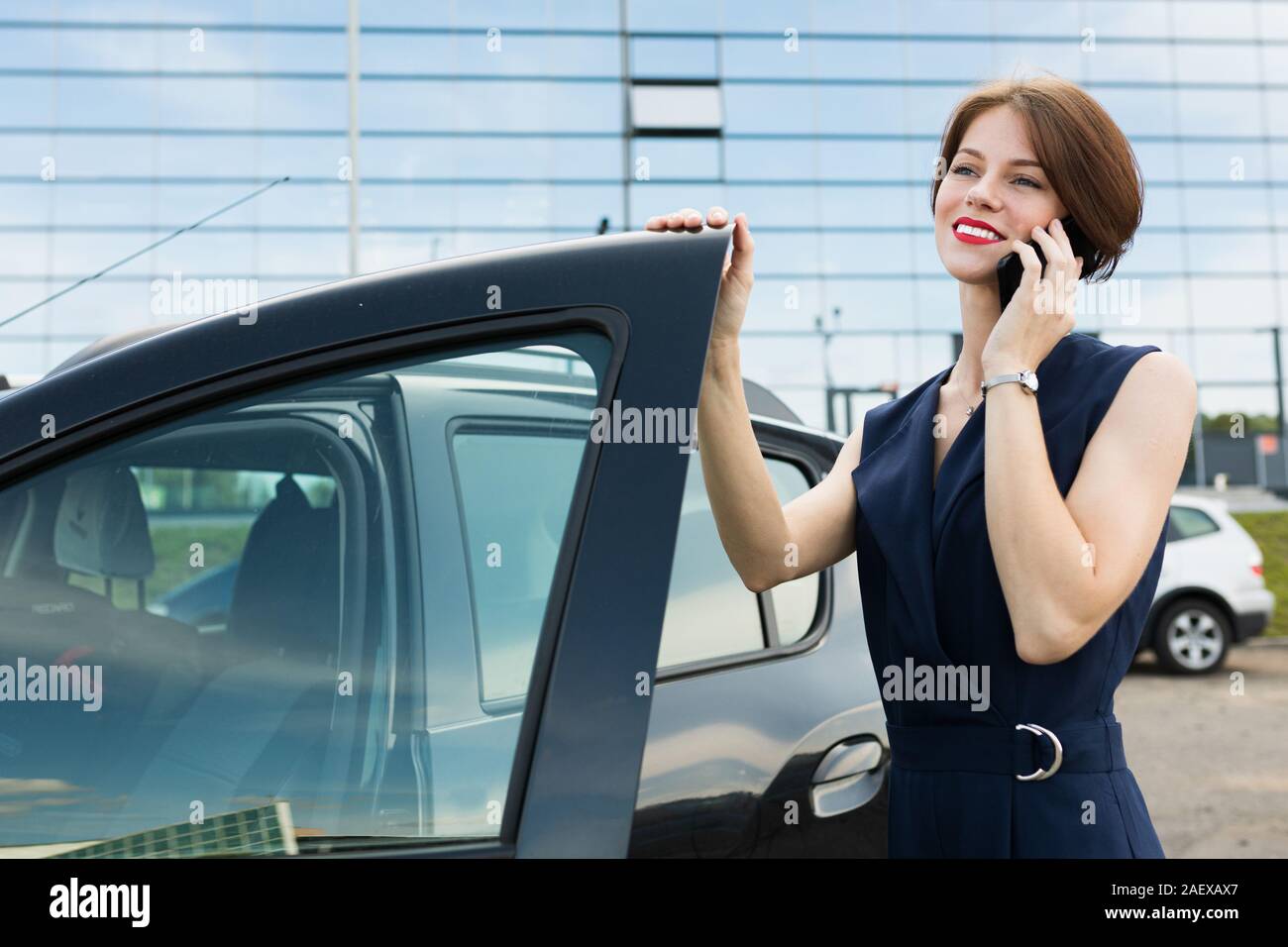 Beautiful girl in strict style of clothing gets out of the car for an ...