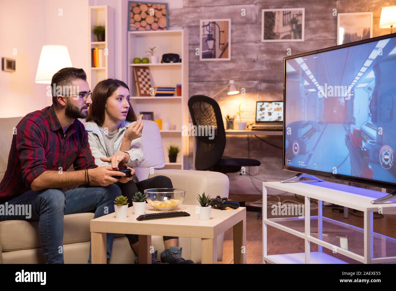Boyfriend playing video games on television using controller while ...