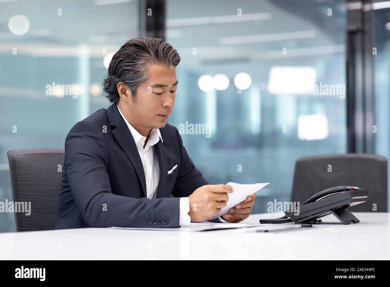 Serious businessman looking through documents hi-res stock photography ...