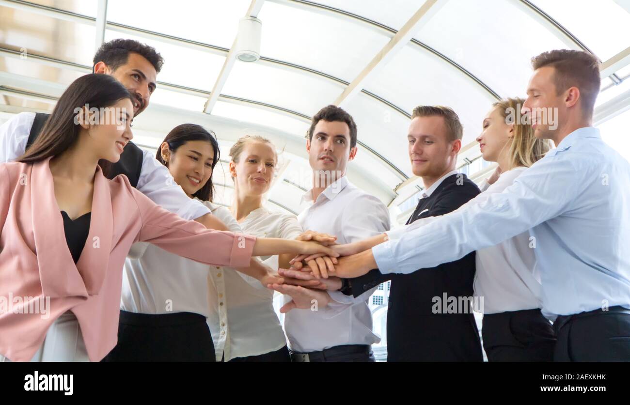 Portrait of a positive team standing in office cheerful with business ...