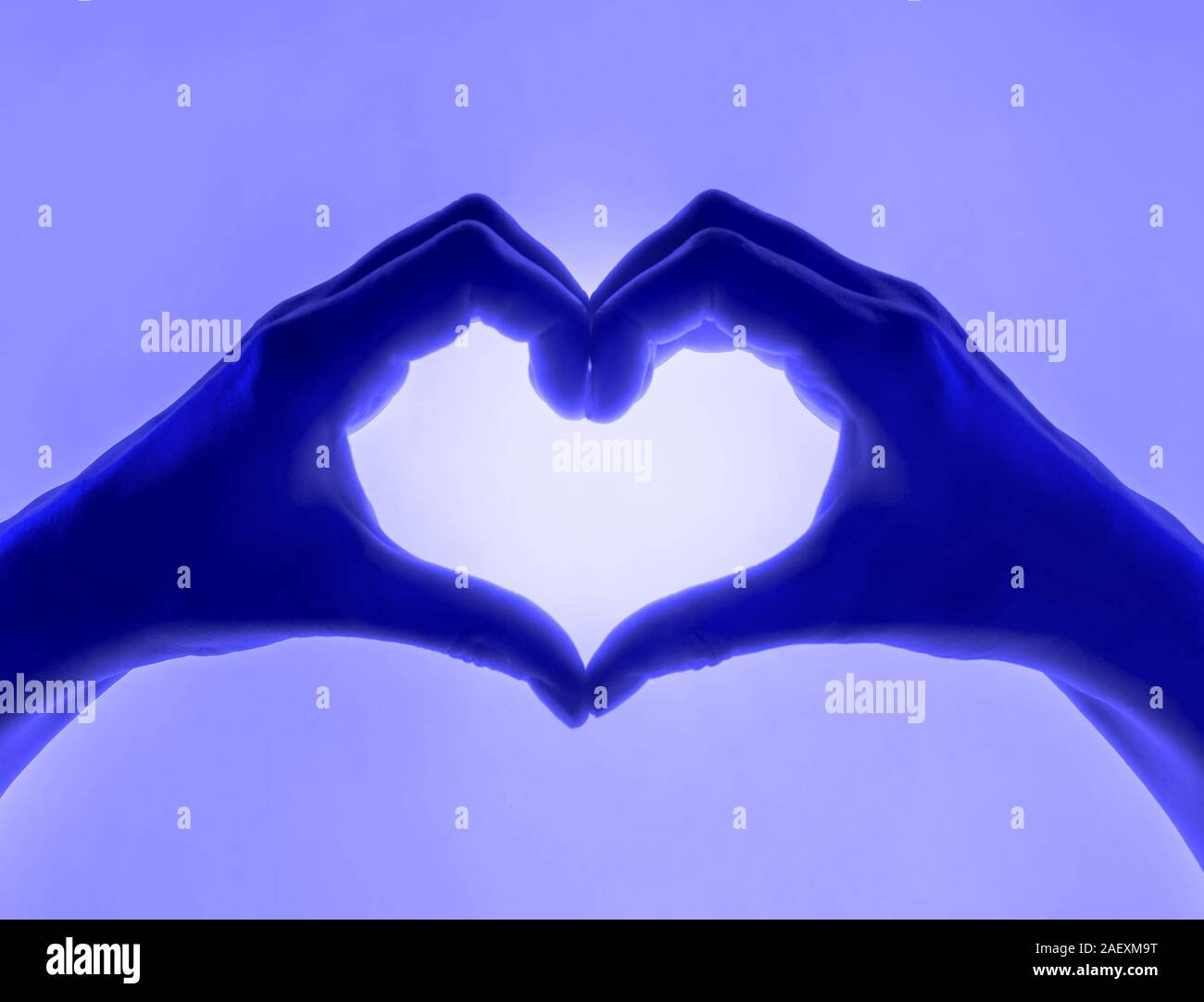 Hands in the form of heart blue shades background. heart symbol with ...