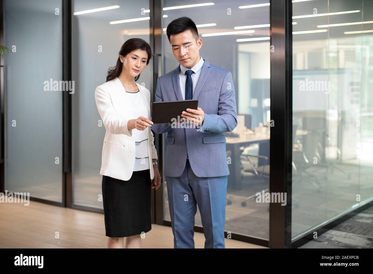 Two successful business people using digital tablet Stock Photo - Alamy
