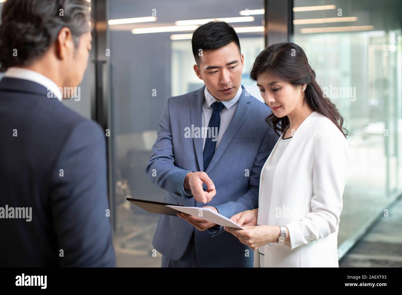 Successful business people talking in office hallway Stock Photo - Alamy