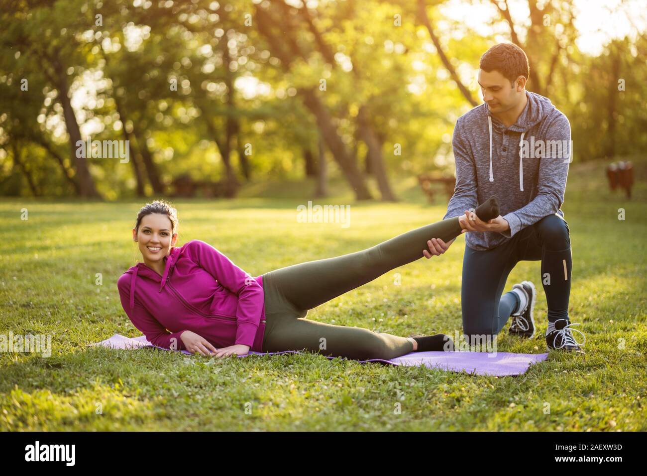 Physical therapist is showing exercises for sciatica recovery to young ...