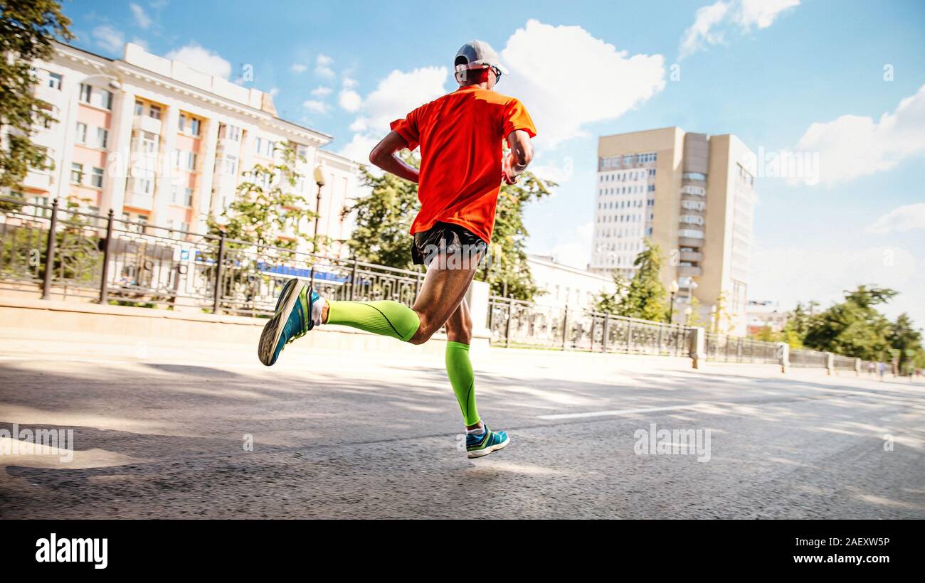 back athlete runner run on city street in summer day with blue sky and ...