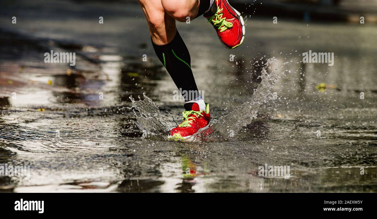 feet runner athlete run puddle on road, water splash Stock Photo - Alamy