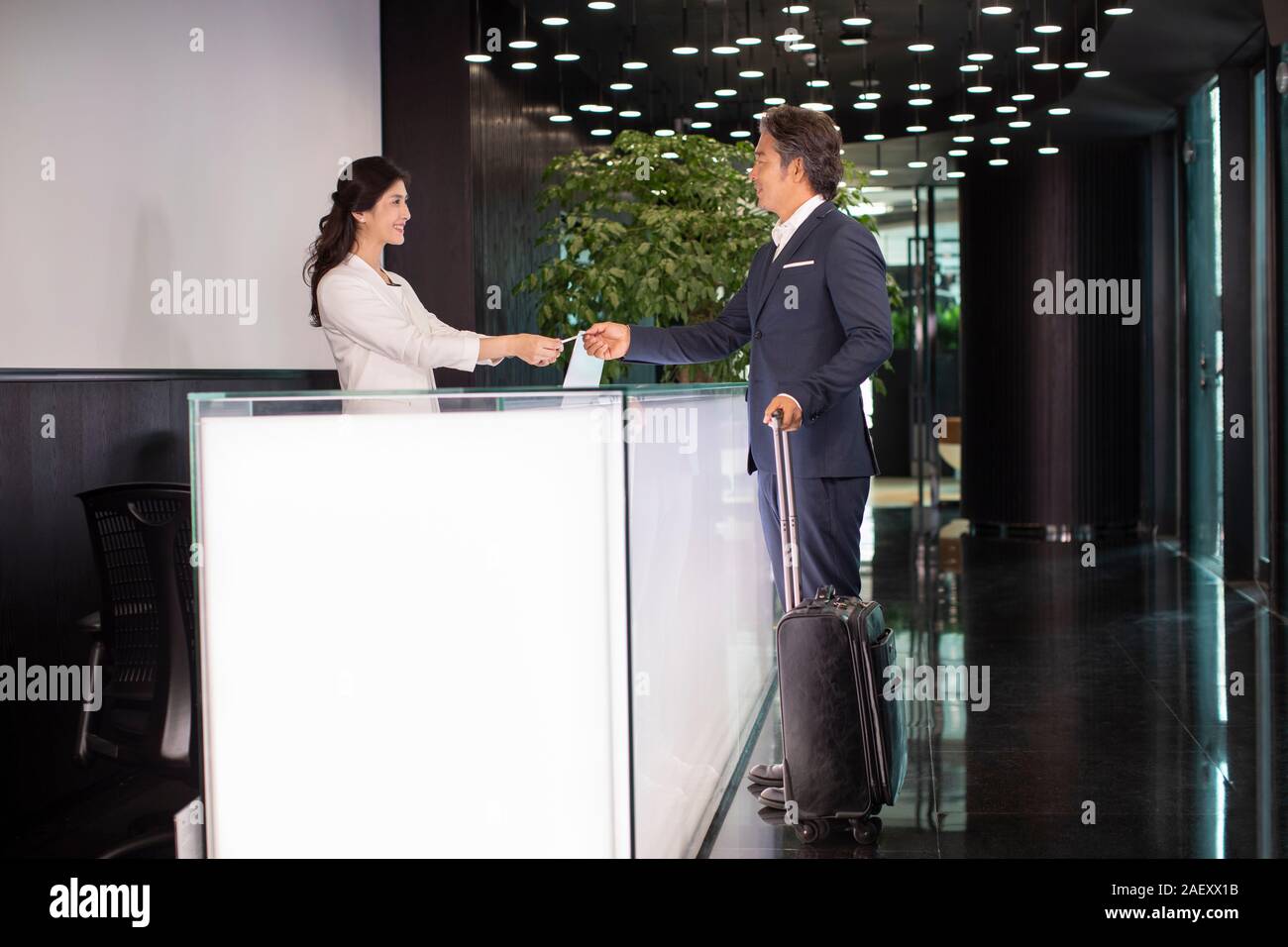 Receptionist giving business card to businessman Stock Photo - Alamy
