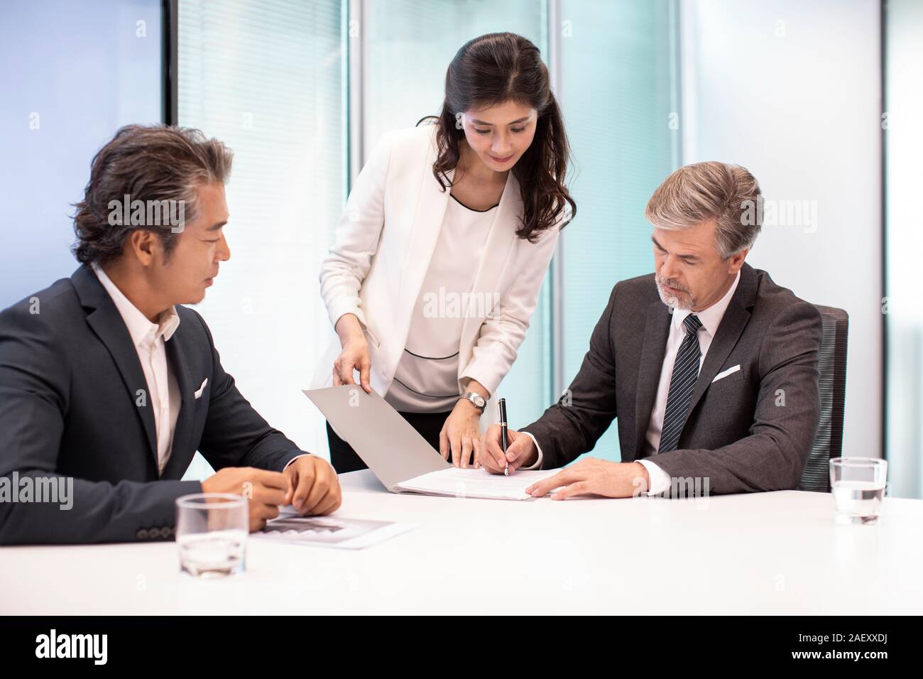 Business people signing contract in conference room Stock Photo - Alamy