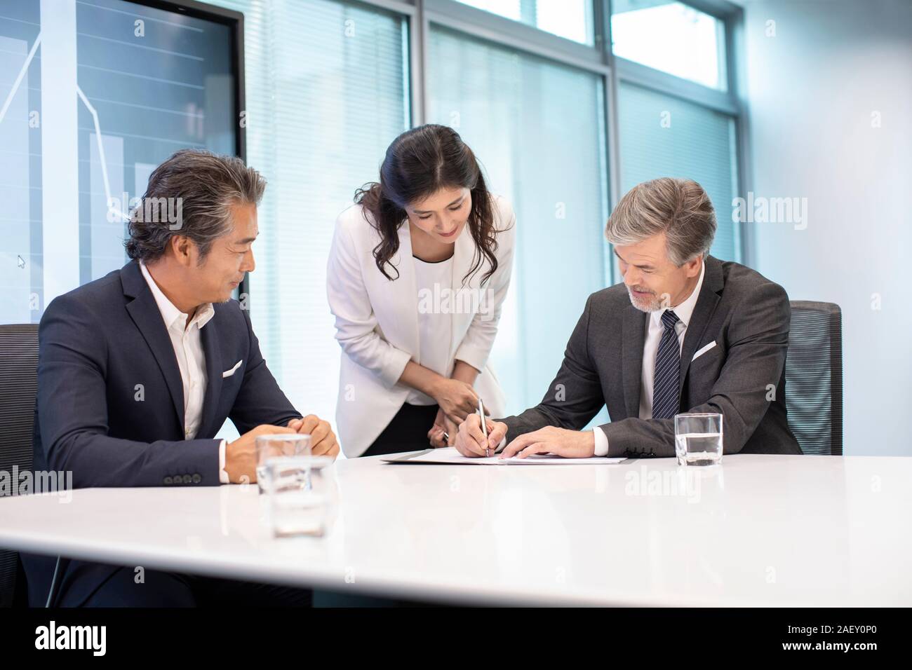 Business people signing contract in conference room Stock Photo - Alamy