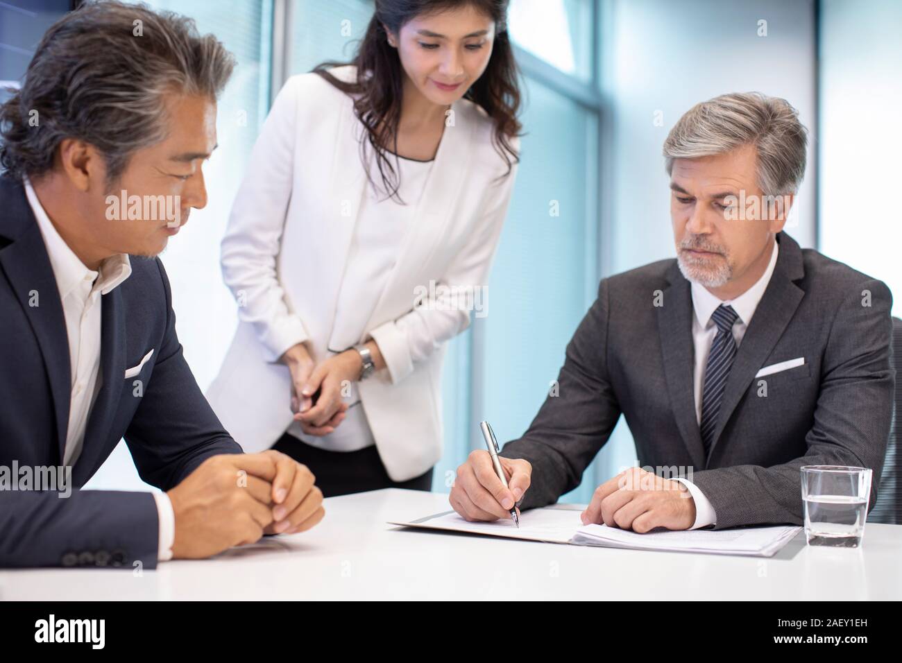 Business people signing contract in conference room Stock Photo - Alamy