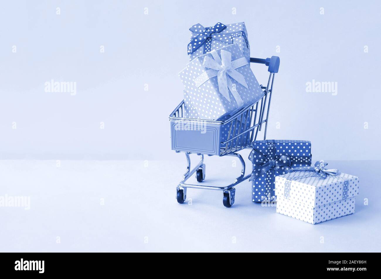 Small gift boxes of different colors with ribbons lies in shopping cart ...