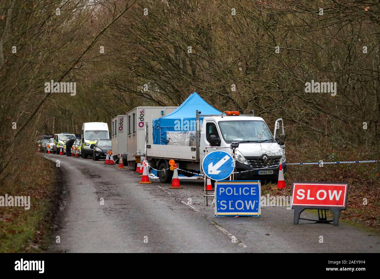 Police vehicles as police forensics teams search ditches and woodland ...