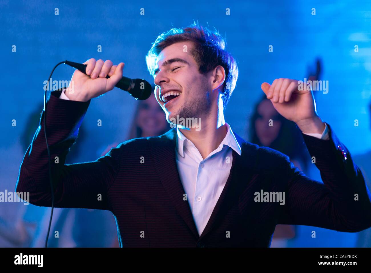 Millennial Guy Singing Song Holding Microphone At Karaoke Night Party ...