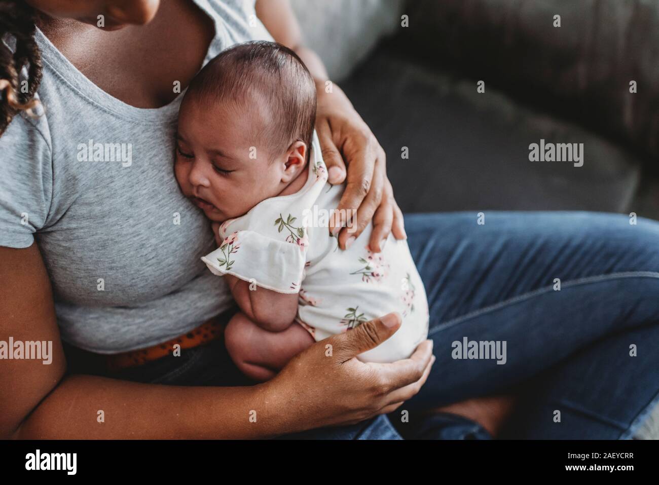 Ethnic mother cradling multiracial sleeping infant Stock Photo - Alamy