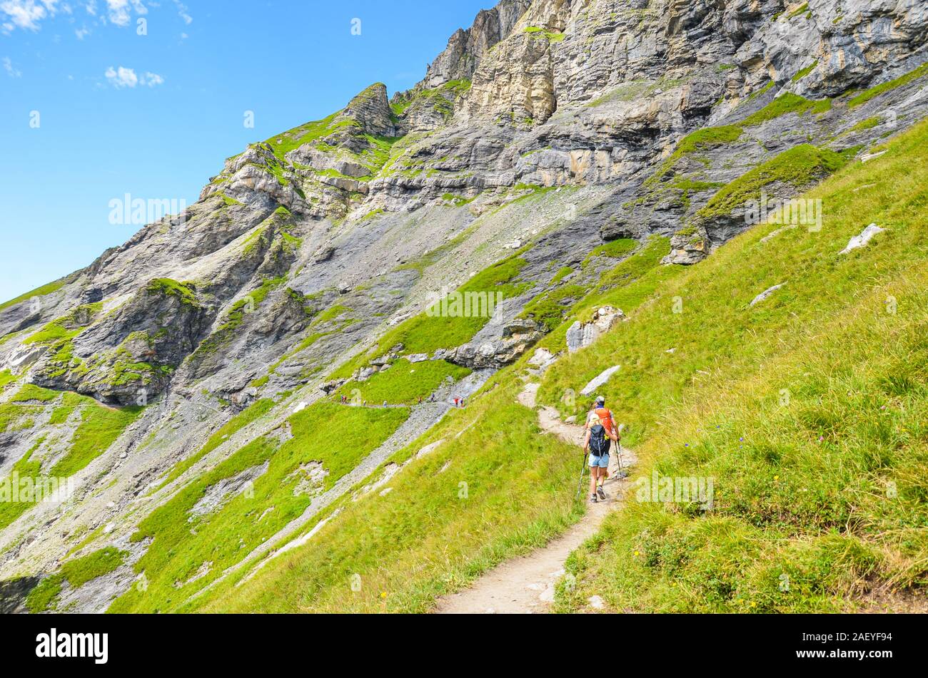 Hiking path in the Swiss Alps photographed in the summer season. Hikers ...