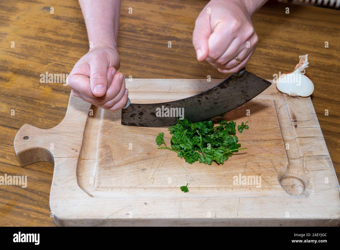 Woman chopping parsley in her kitchen Stock Photo - Alamy