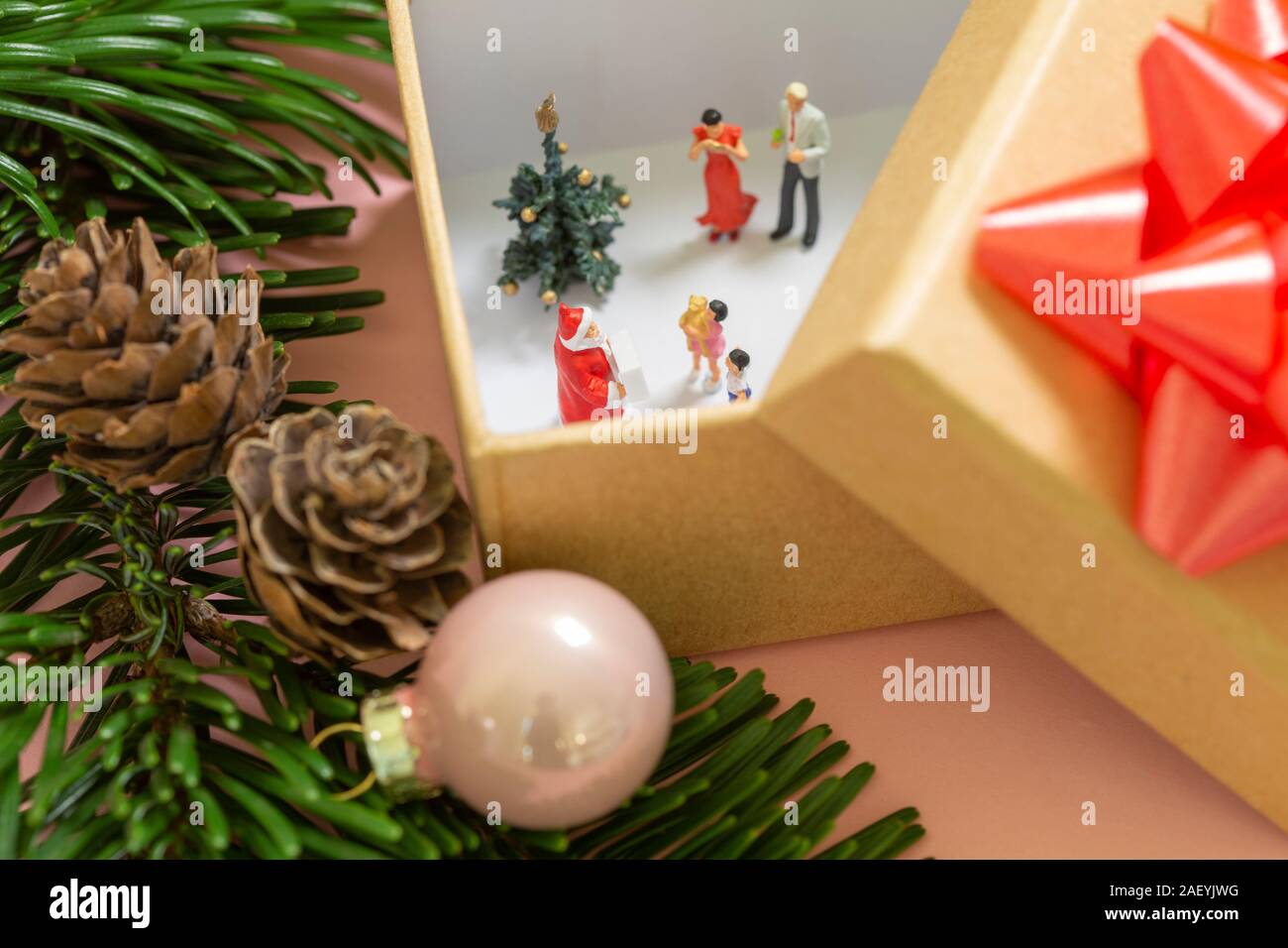 A miniature family is celebrating christmas in a small gift box ...