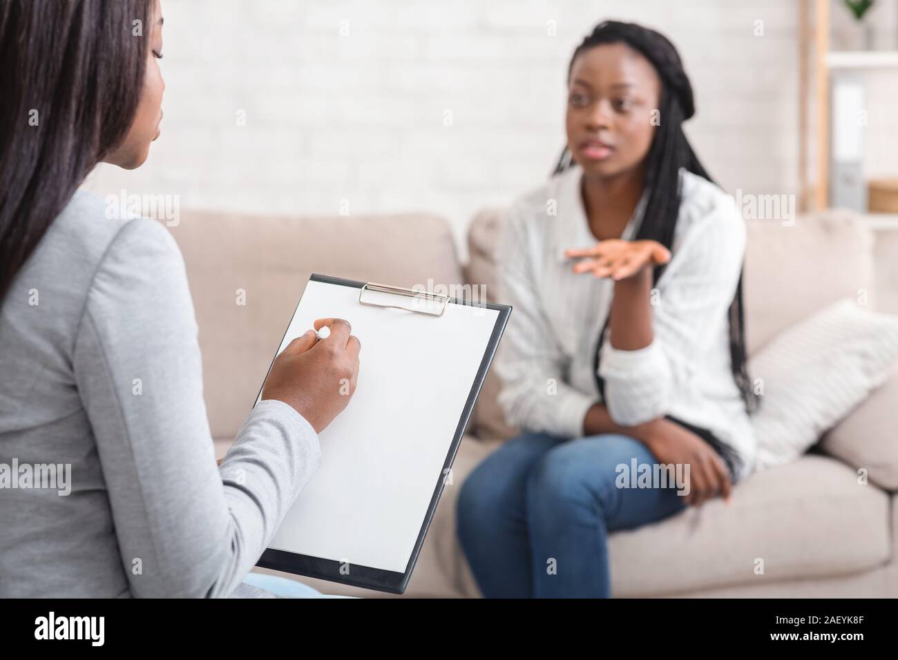 Psychologist Taking Notes During Therapy Session With Her Emotional