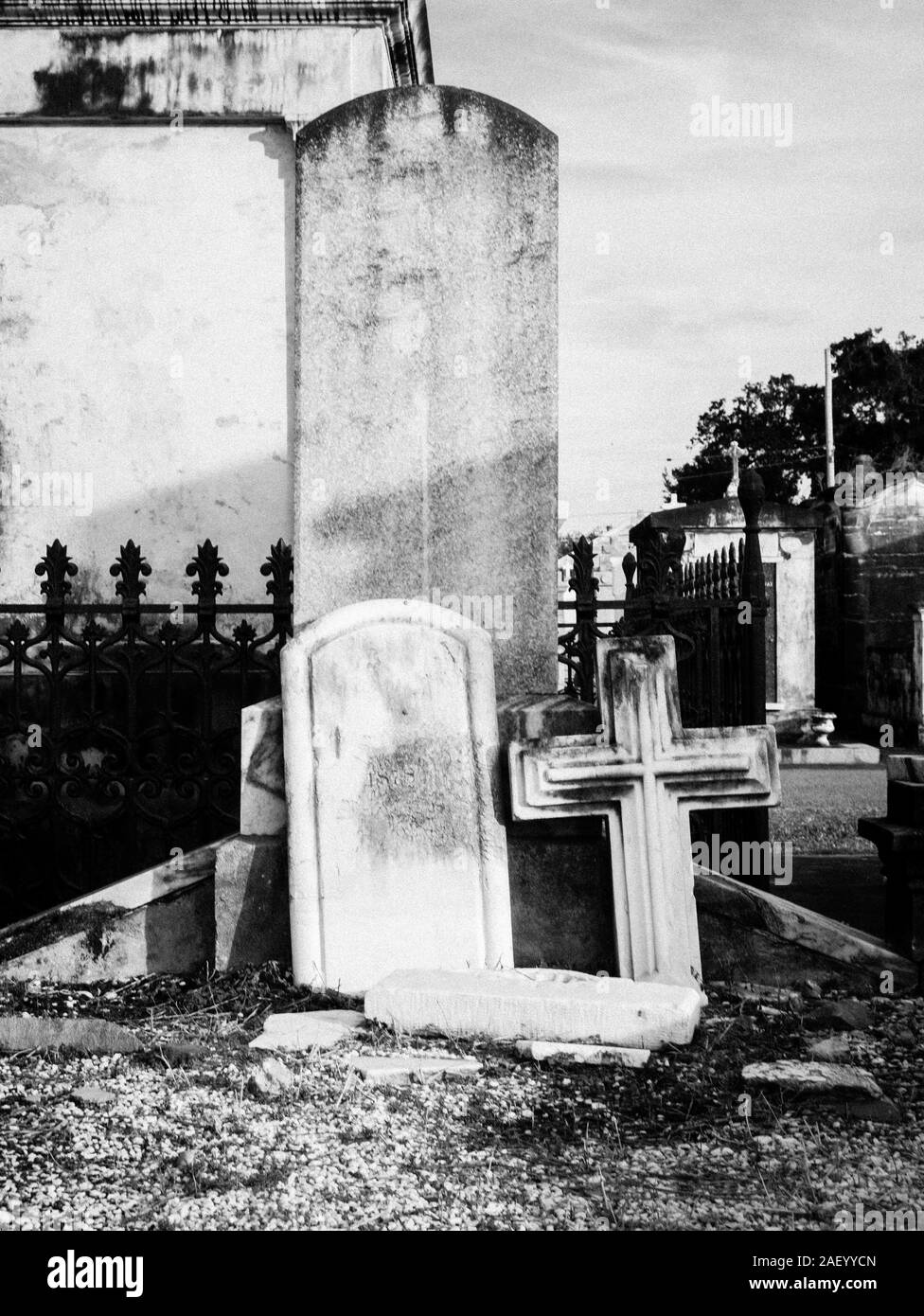 Tombstone and cross in an old lugubrious cemetery, black and white ...