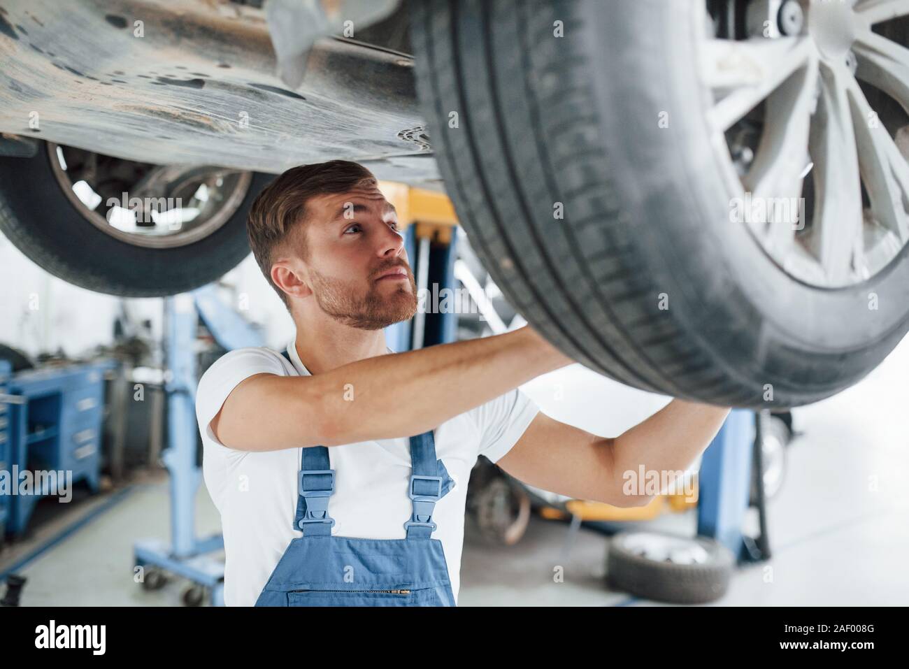 Repairing in action. Employee in the blue colored uniform works in the ...
