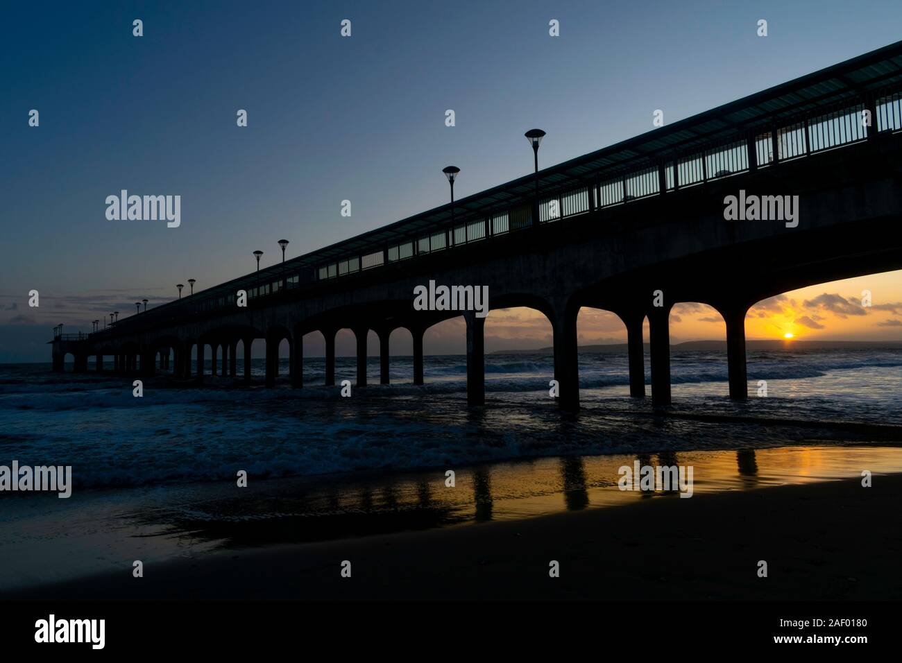 Sunset at Boscombe Pier, Bournemouth with pier in silhouette and rough ...