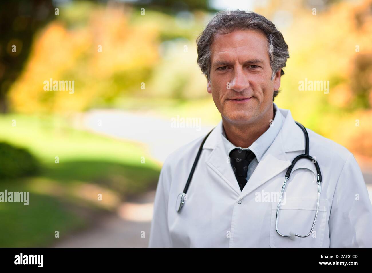 Male doctor poses for a portrait in a park Stock Photo - Alamy