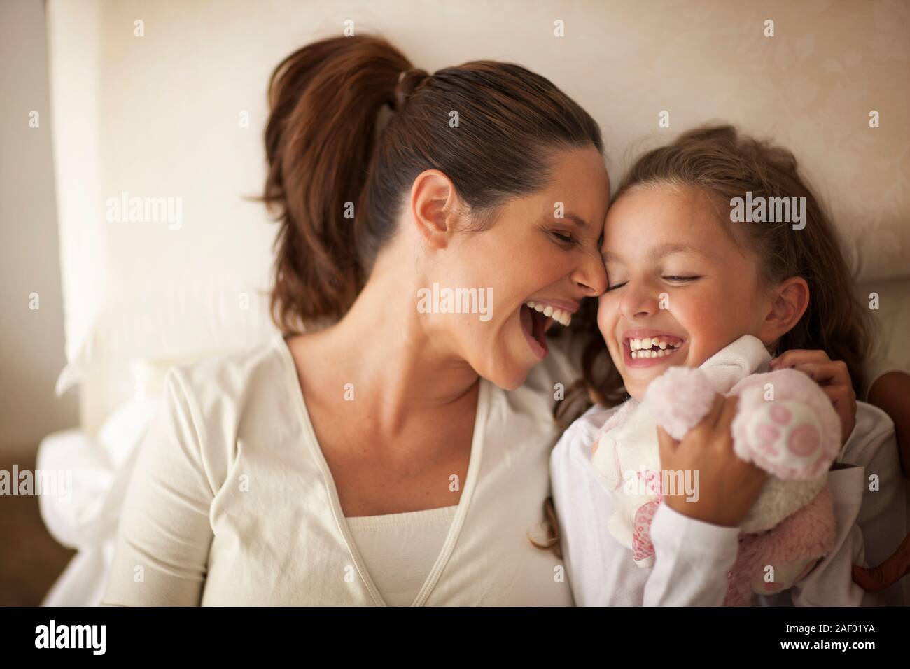 Woman snuggling in bed with her daughter Stock Photo - Alamy
