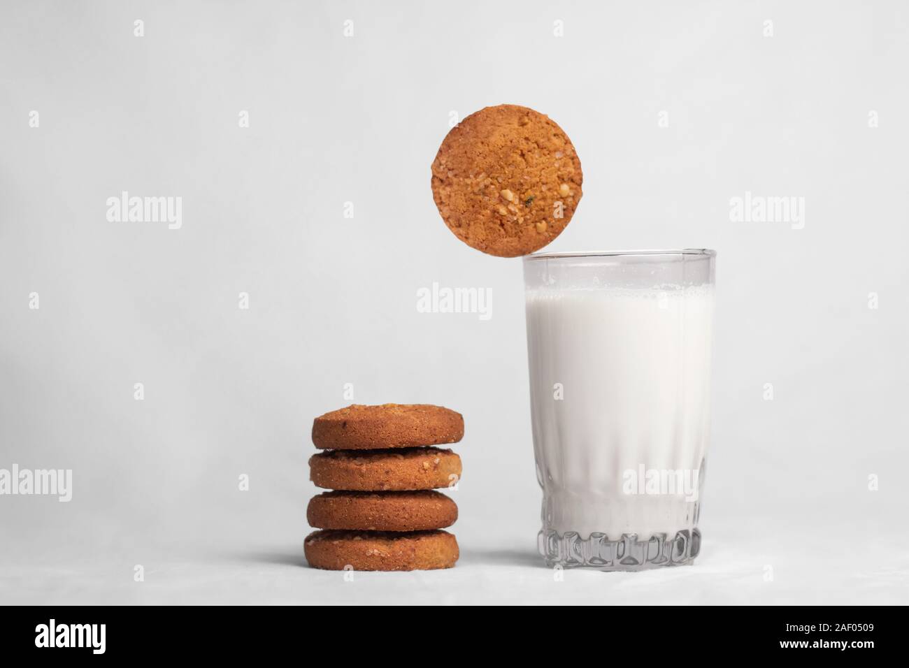 cookies falling into glass of milk Stock Photo - Alamy
