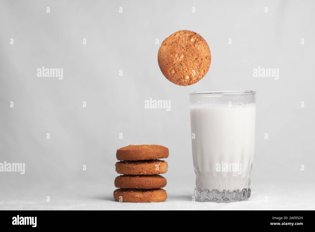 cookies falling into glass of milk Stock Photo - Alamy