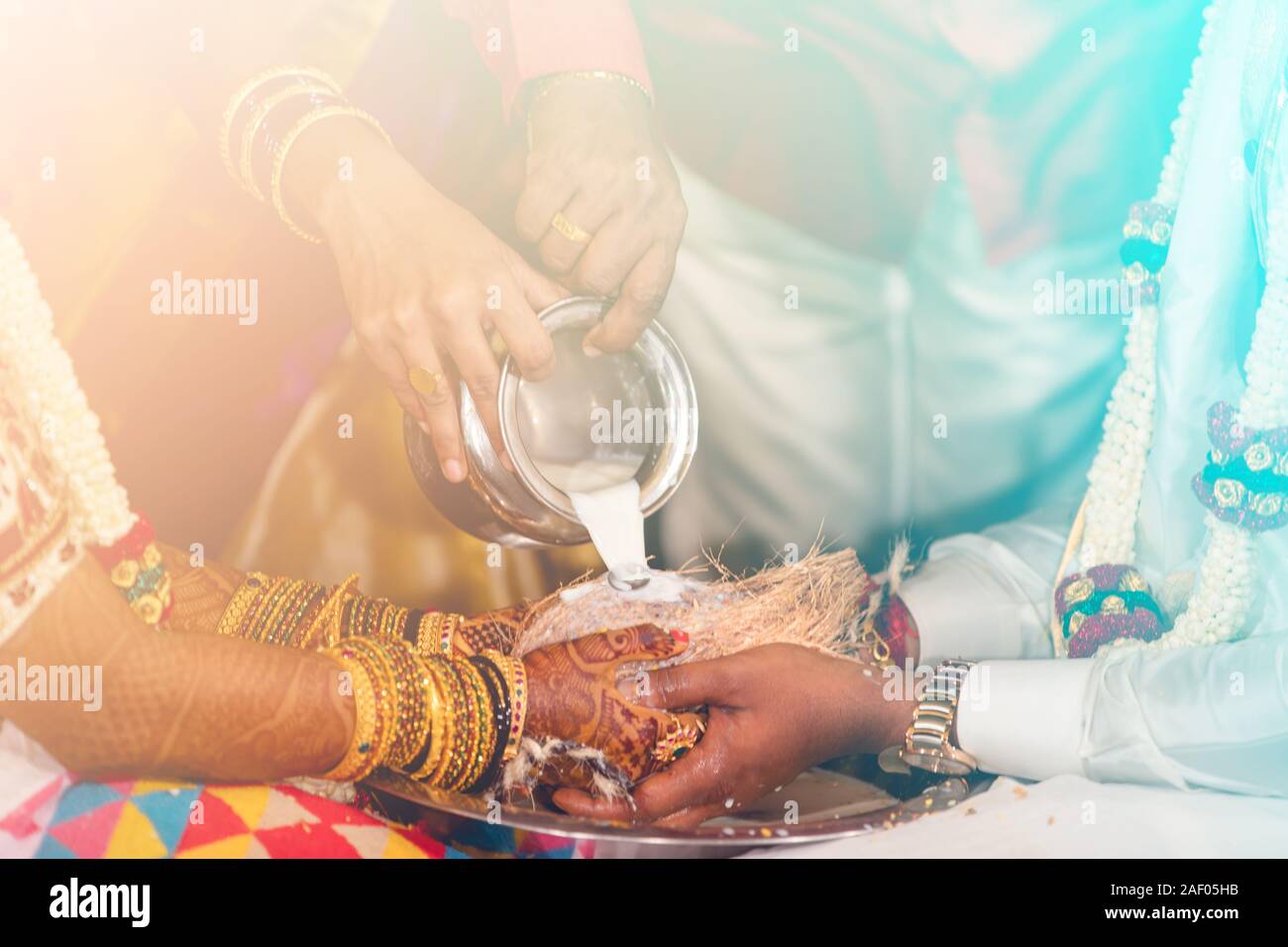 south indian bride and groom holding coconut. milk pouring ritual Stock ...