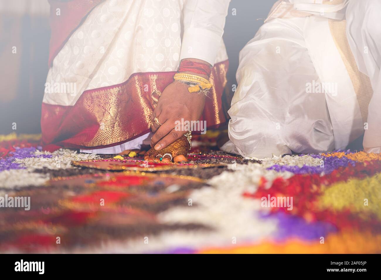 South Indian wedding ritual Saptapadi. Groom holding brides foot during ...