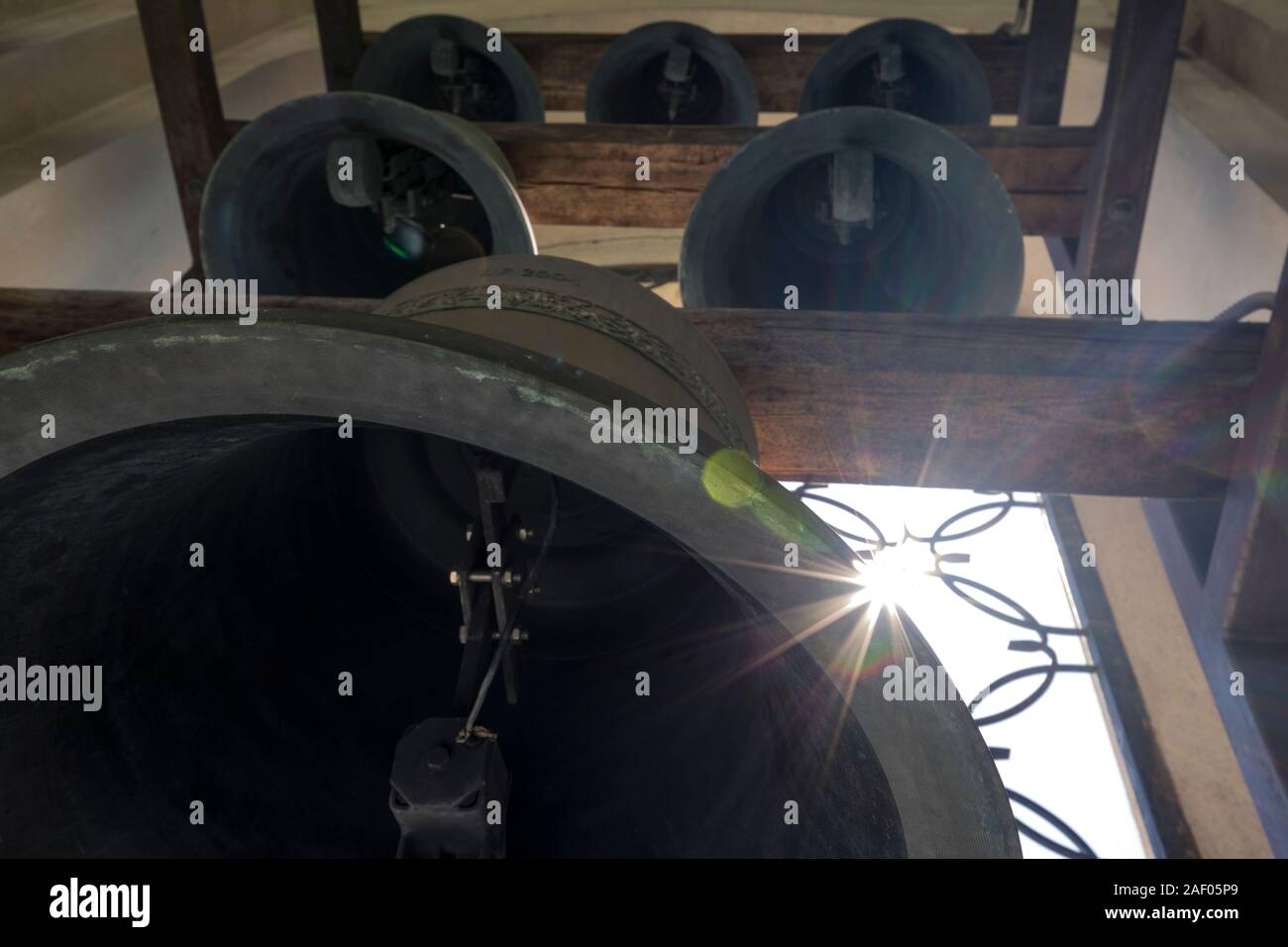 Antient bronze bells hanging on wooden beam and ringing. Shining sun ...