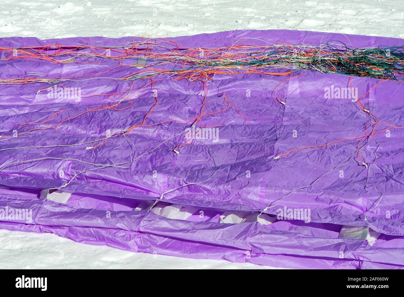 Purple fabric parachute canopy preparing for packing Stock Photo - Alamy